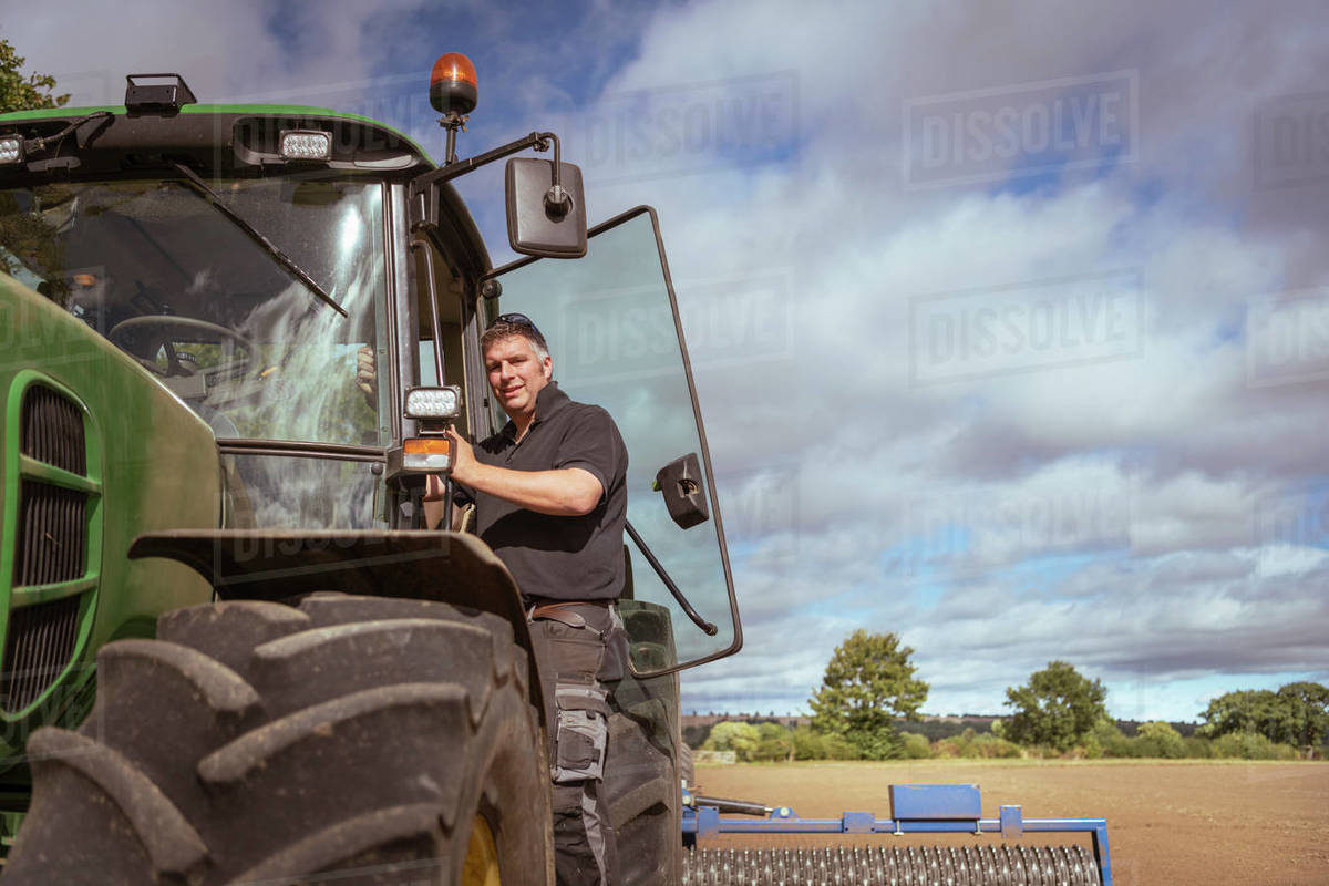 Portrait of farmer on tractor in field - Royalty-free Stock Photo ...