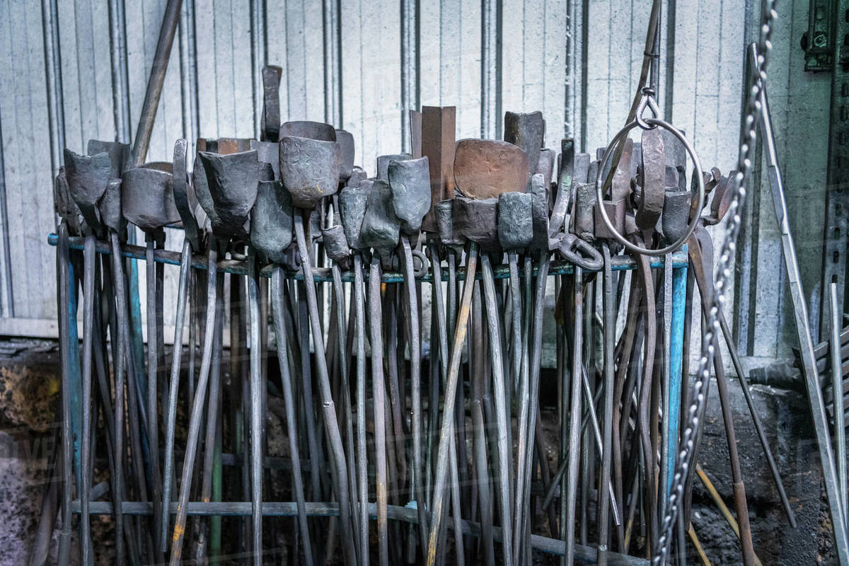 Rows of tools and tongs in industrial forge - Stock Photo - Dissolve