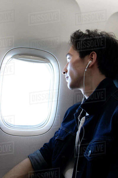 Man sitting in airplane - Royalty-free Stock Photo | Dissolve