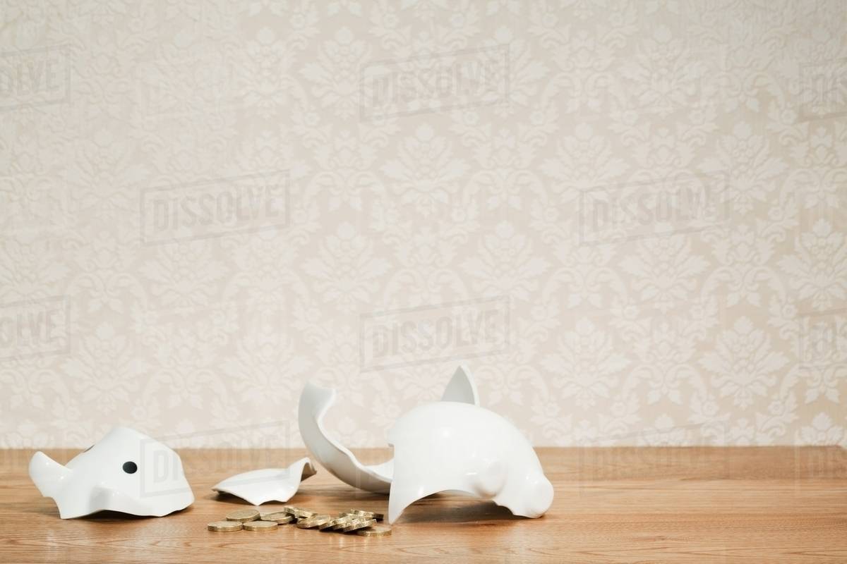 Smashed piggy bank and coins - Stock Photo - Dissolve