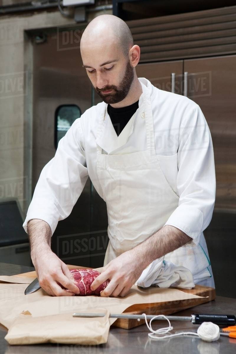 Butcher preparing beef tenderloin - Royalty-free Stock Photo | Dissolve