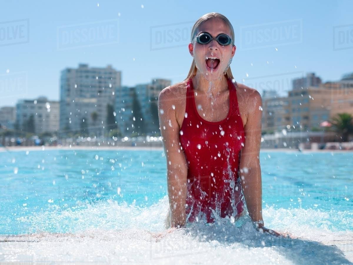 Young woman exiting swimming pool - Royalty-free Stock Photo | Dissolve