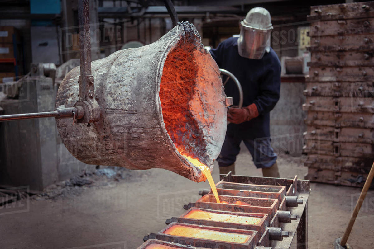 Worker pouring ingots of brass in brass foundry - Stock Photo - Dissolve