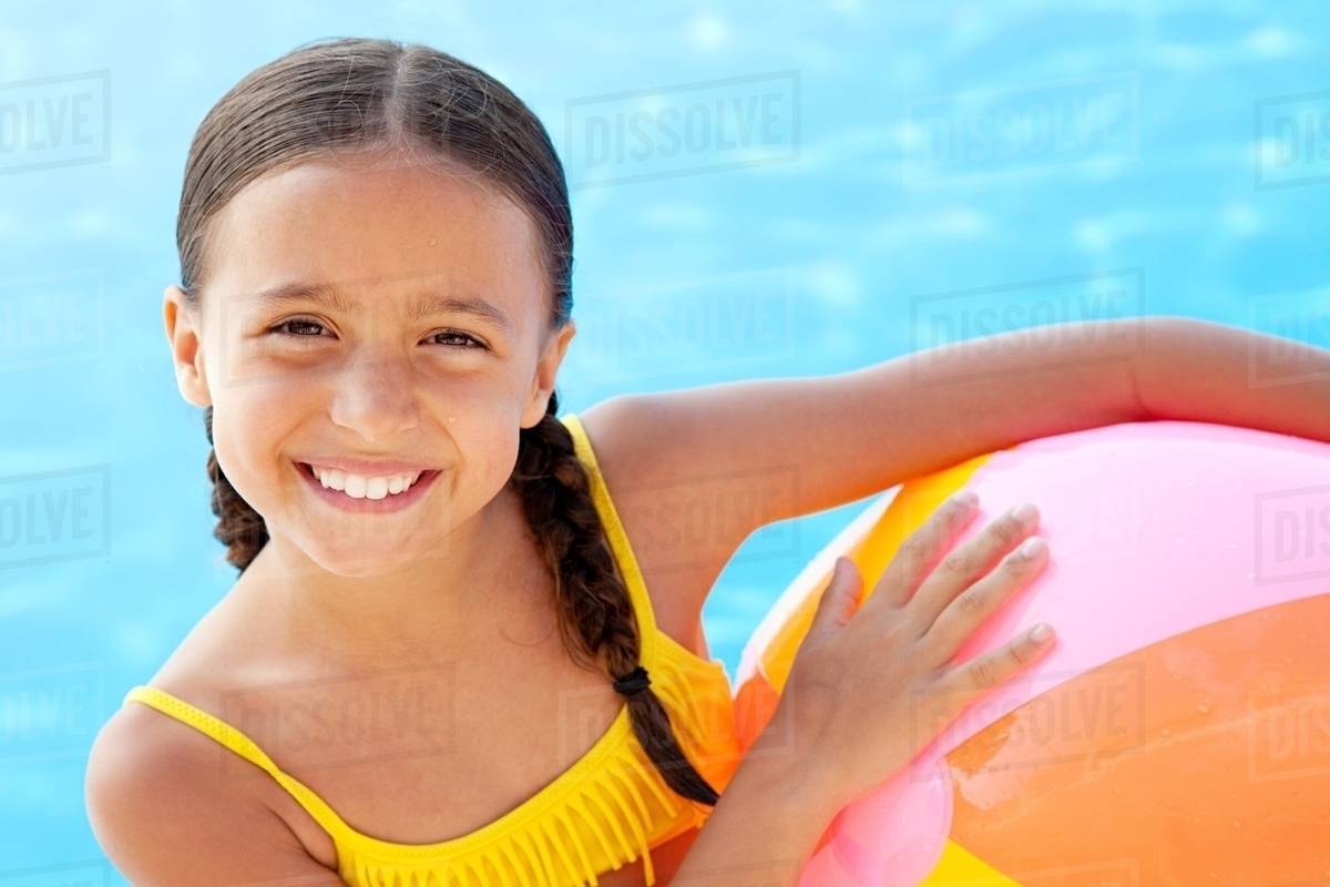 Girl with beach ball by swimming pool, portrait - Royalty-free Stock ...