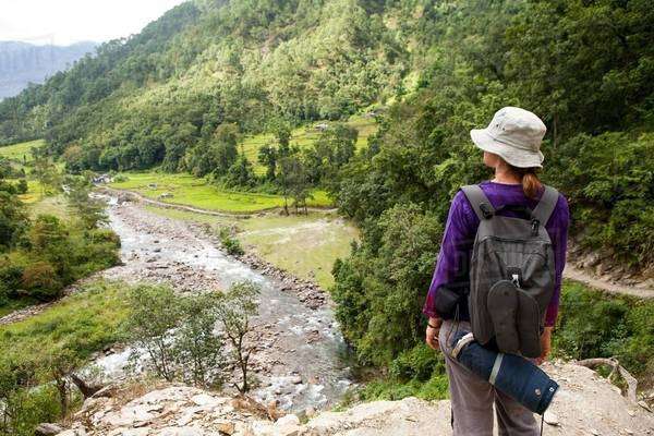 Tourist looking over valley, Nepal - Stock Photo - Dissolve