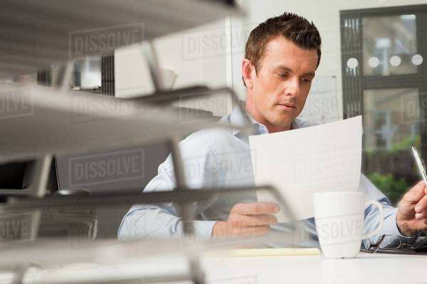 Office worker checking a document - Royalty-free Stock Photo | Dissolve