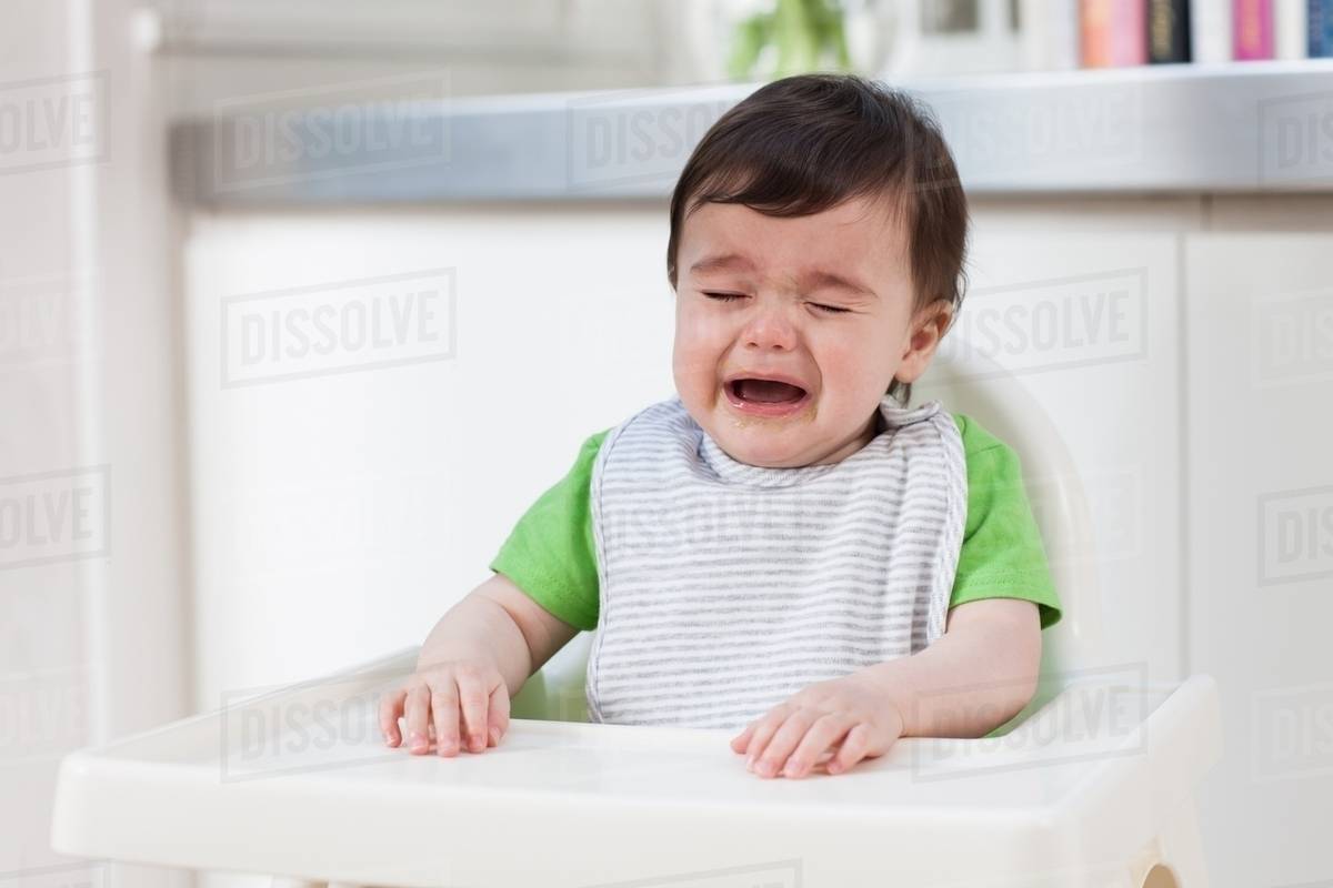 Baby boy in high chair, crying - Royalty-free Stock Photo | Dissolve