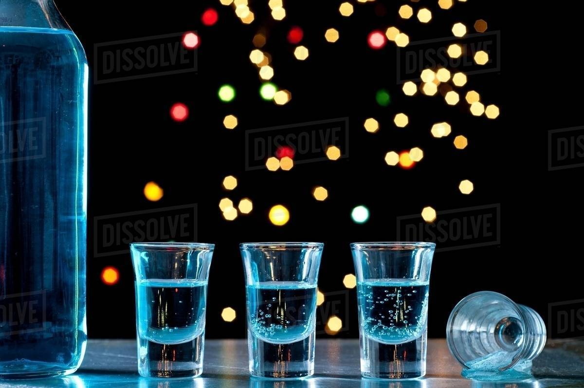 Bottle and shots of blue alcohol - Royalty-free Stock Photo | Dissolve