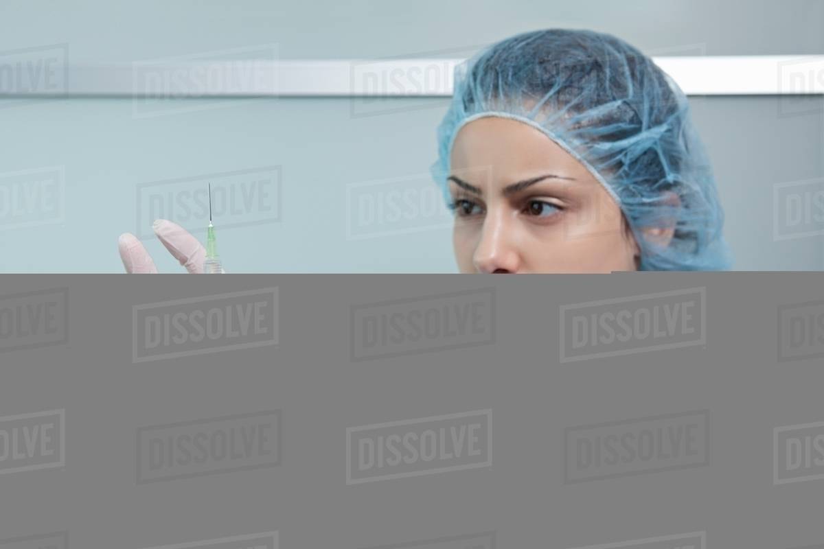 Surgeon holding injection - Stock Photo - Dissolve
