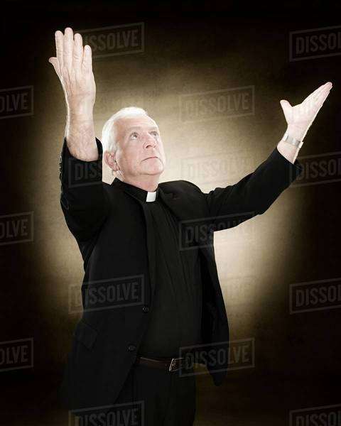 Priest with his arms raised - Royalty-free Stock Photo | Dissolve