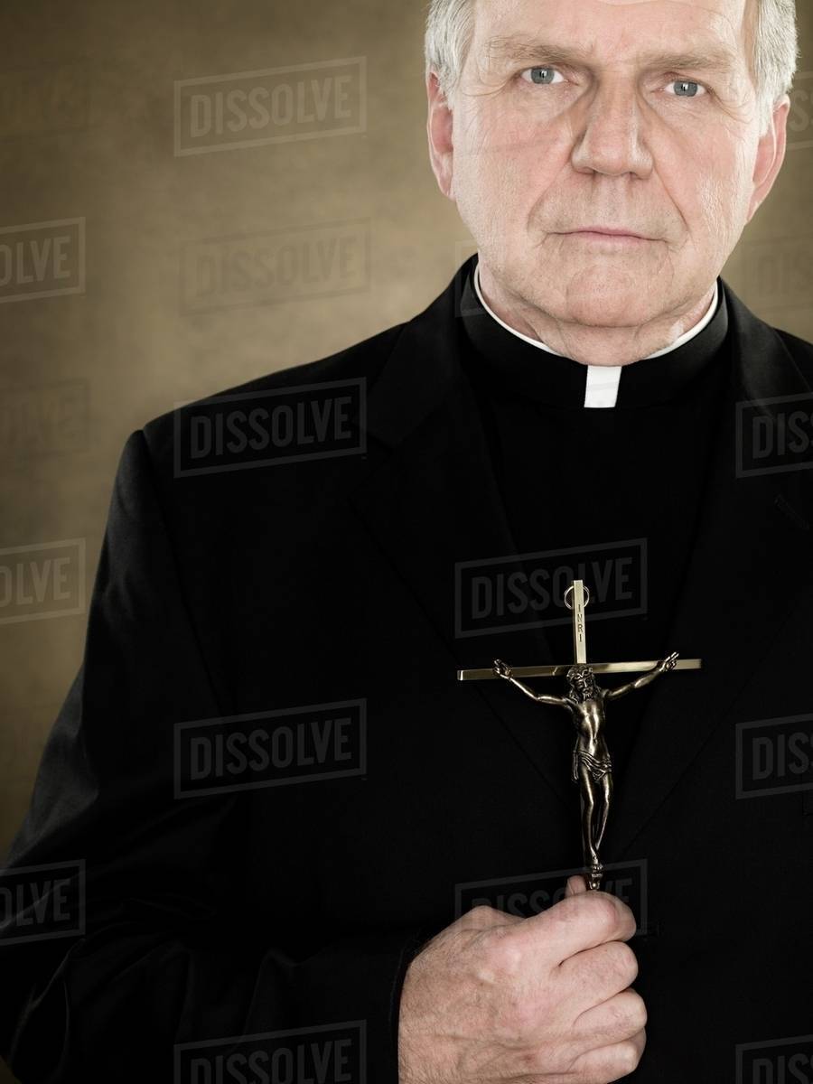 A priest holding a crucifix - Royalty-free Stock Photo | Dissolve