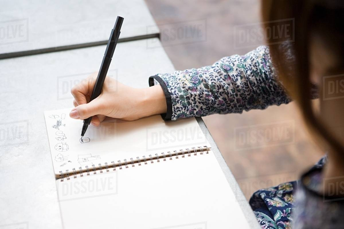 Woman drawing in notebook - Royalty-free Stock Photo | Dissolve