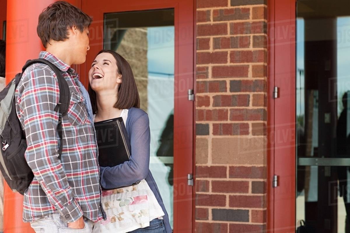 High school students outside school building - Stock Photo - Dissolve