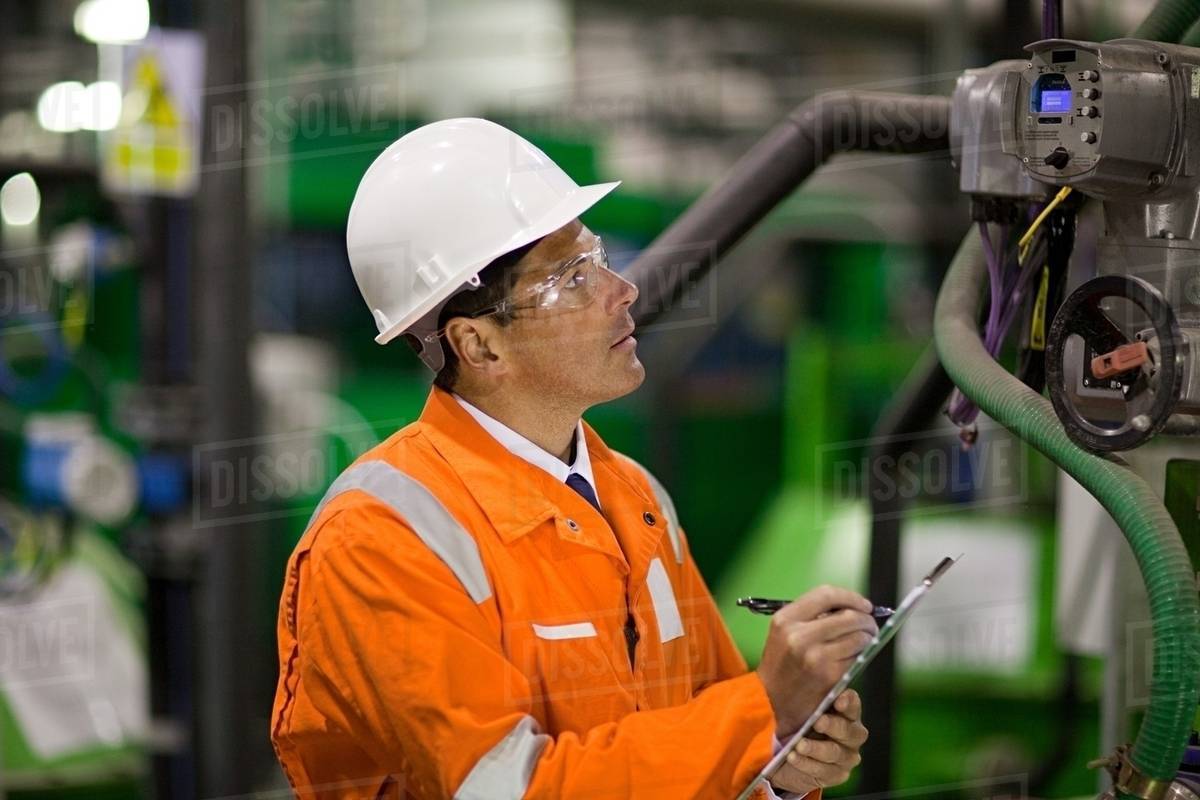 Engineer inspecting machinery in factory - Stock Photo - Dissolve