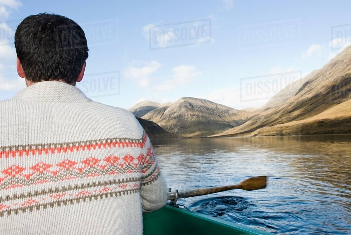 Man in rowing boat on lake - Royalty-free Stock Photo | Dissolve