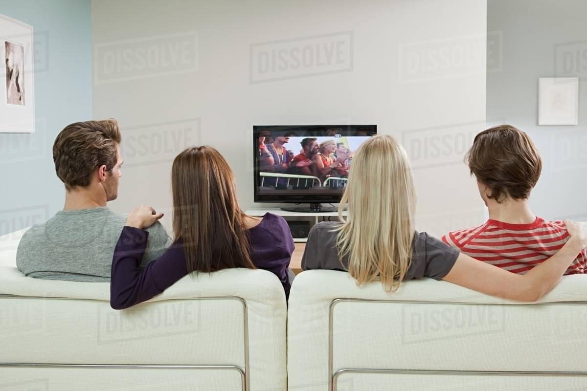 Two couples watching television - Stock Photo - Dissolve