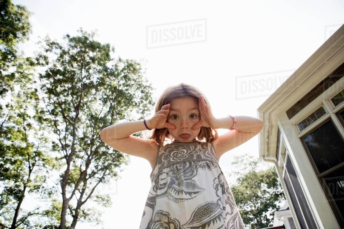 Portrait of young girl pulling a face - Stock Photo - Dissolve