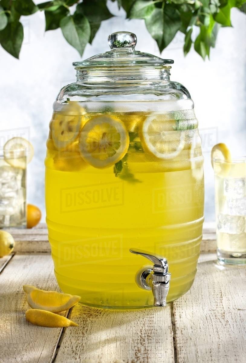Glass barrel with tap dispenser containing fresh lemonade drink ...