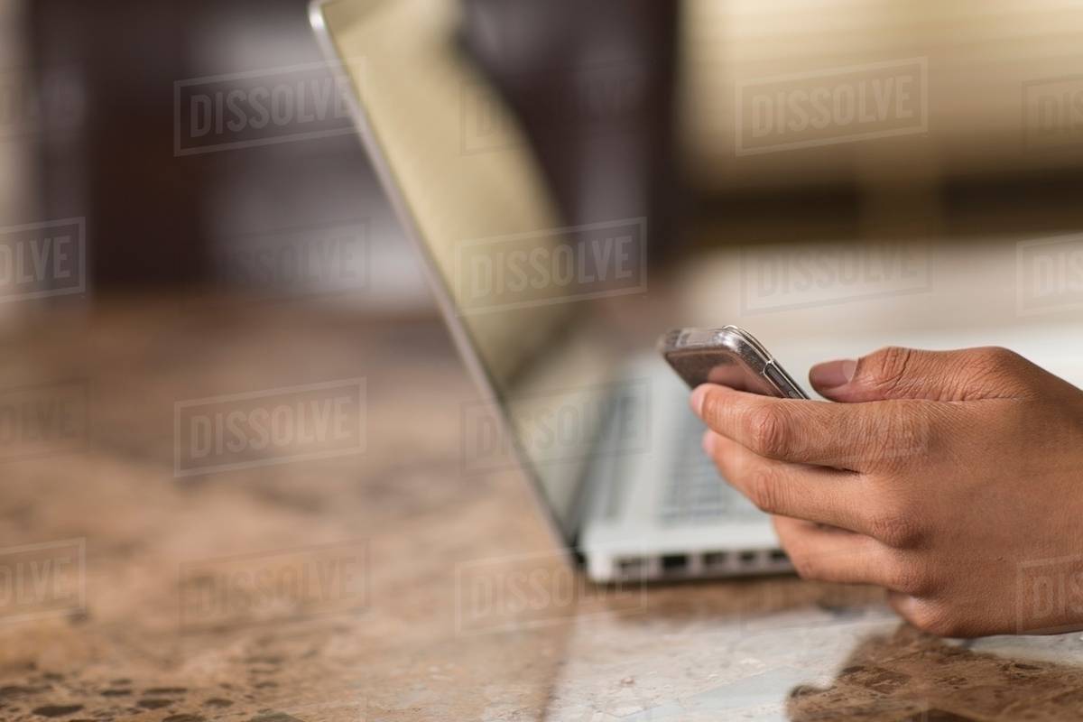 Hand of teenage boy at dining table texting on smartphone - Stock Photo ...