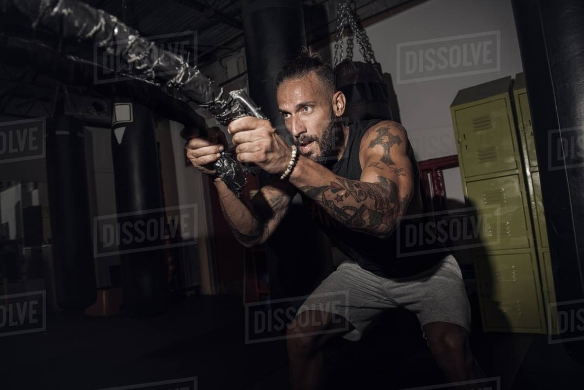 Male boxer pulling battle rope in gym - Stock Photo - Dissolve