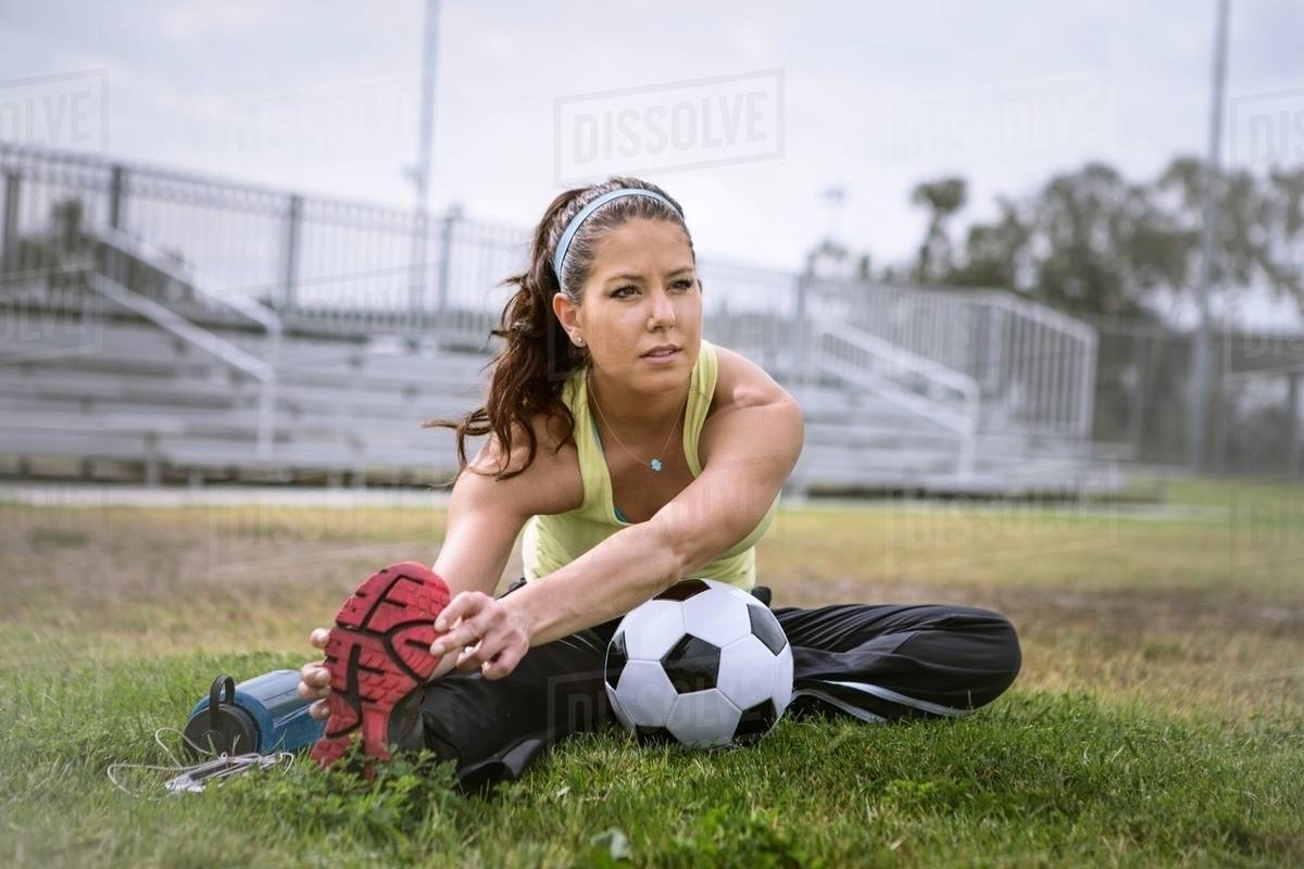 Soccer player stretching in field - Royalty-free Stock Photo | Dissolve