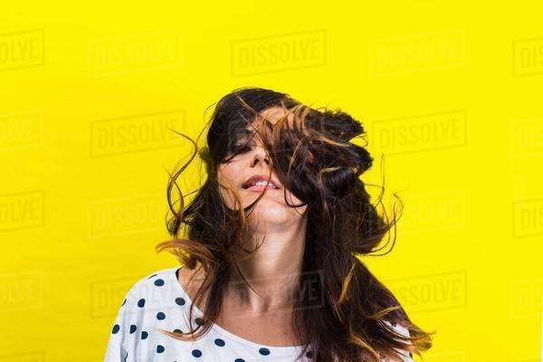 Portrait of young woman flicking hair - Royalty-free Stock Photo | Dissolve