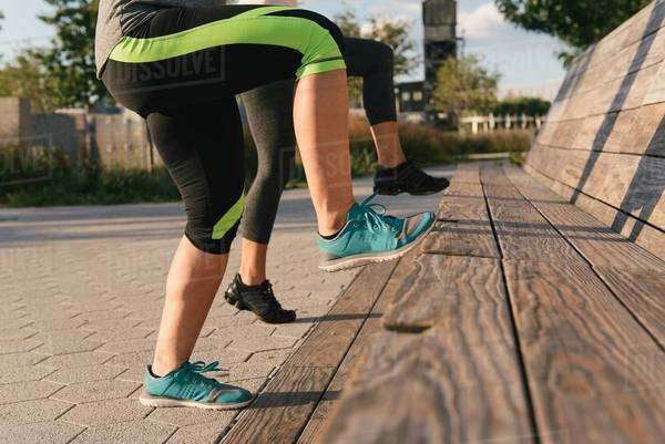 Two friends exercising together, doing leg lifts outdoors - Stock Photo ...