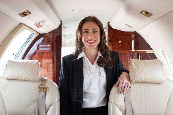 Portrait of female flight attendant on private jet - Royalty-free Stock ...