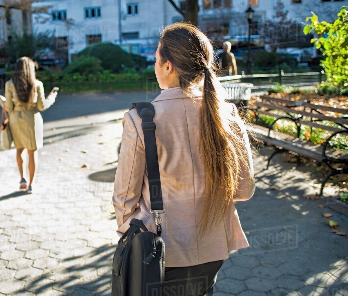 Rear view of young women walking through city park - Royalty-free Stock ...