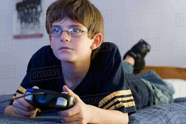 Boy playing a video game - Stock Photo - Dissolve