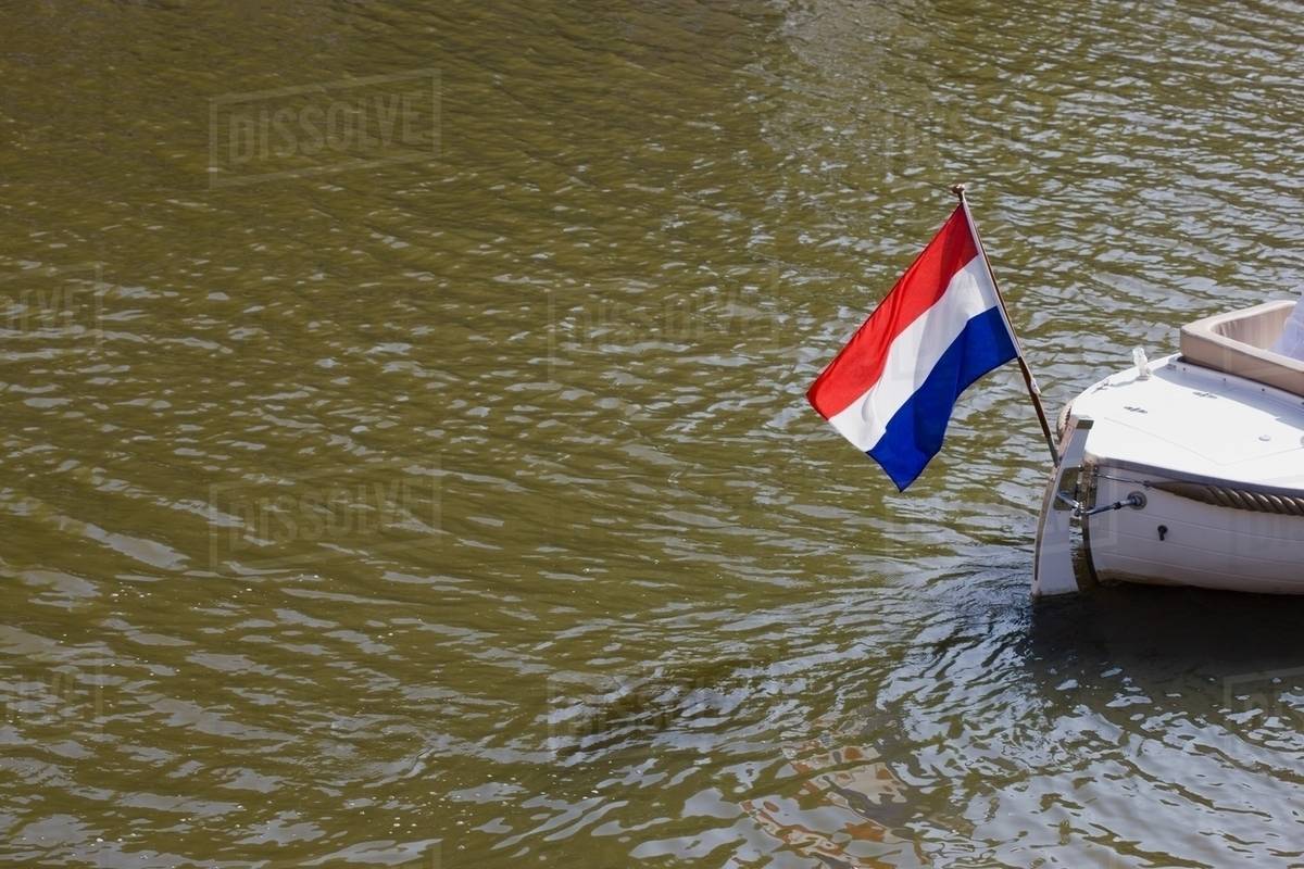 Boat on canal with dutch flag - Royalty-free Stock Photo | Dissolve