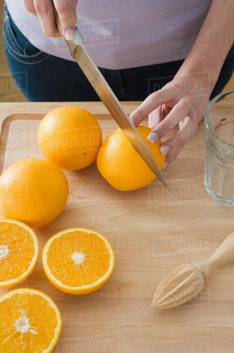 Woman cutting oranges - Royalty-free Stock Photo | Dissolve