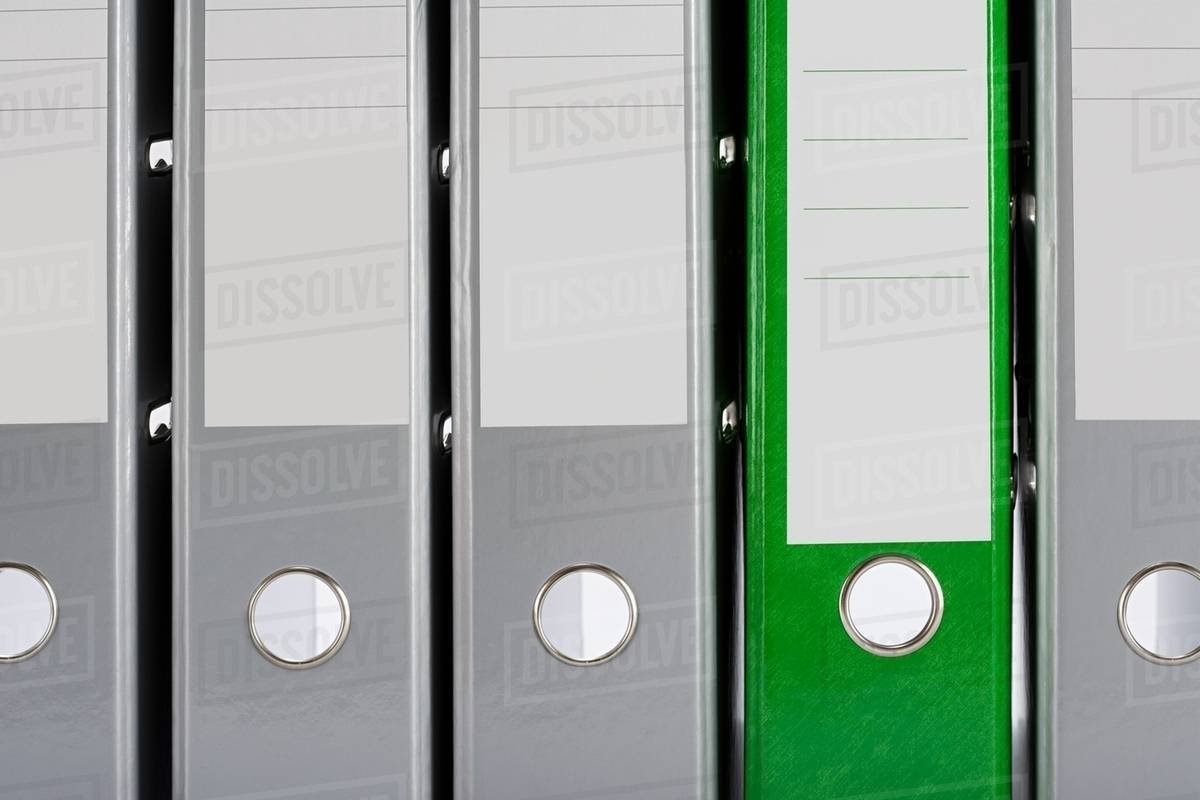 Green folder and grey folders - Stock Photo - Dissolve