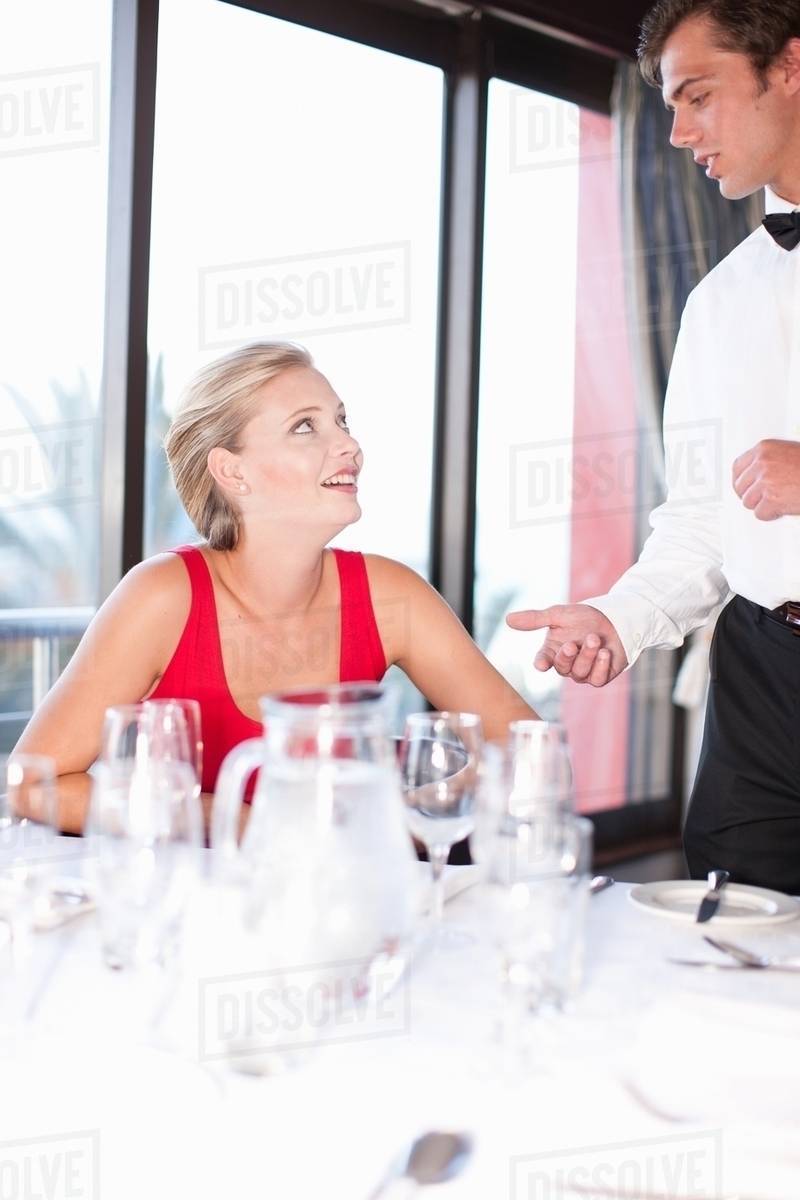 Woman talking to waiter at restaurant - Stock Photo - Dissolve