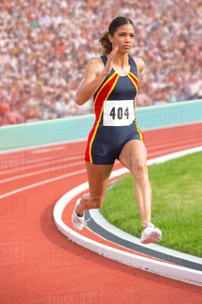 Female athlete running on track - Stock Photo - Dissolve