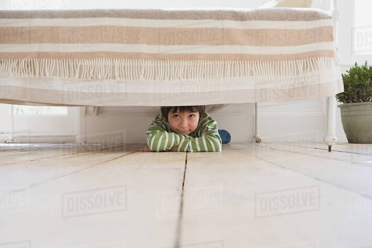 Boy hiding under a bed - Royalty-free Stock Photo | Dissolve