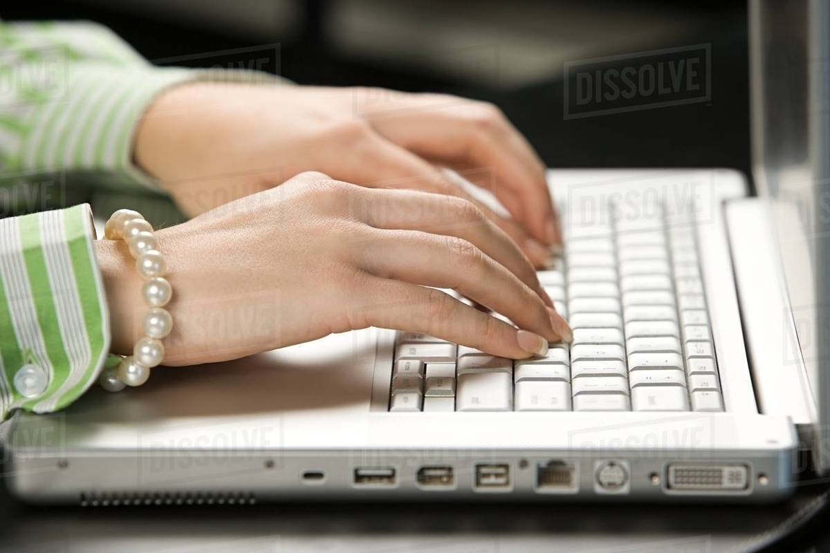 An office worker typing on a laptop - Stock Photo - Dissolve