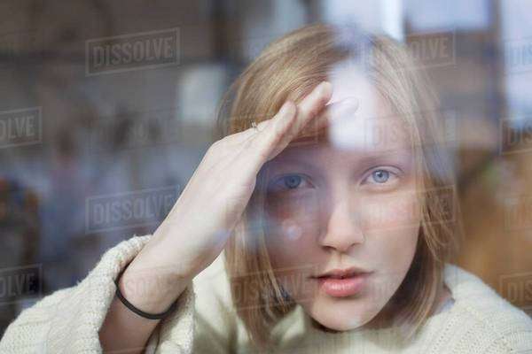 Woman peering through window - Stock Photo - Dissolve