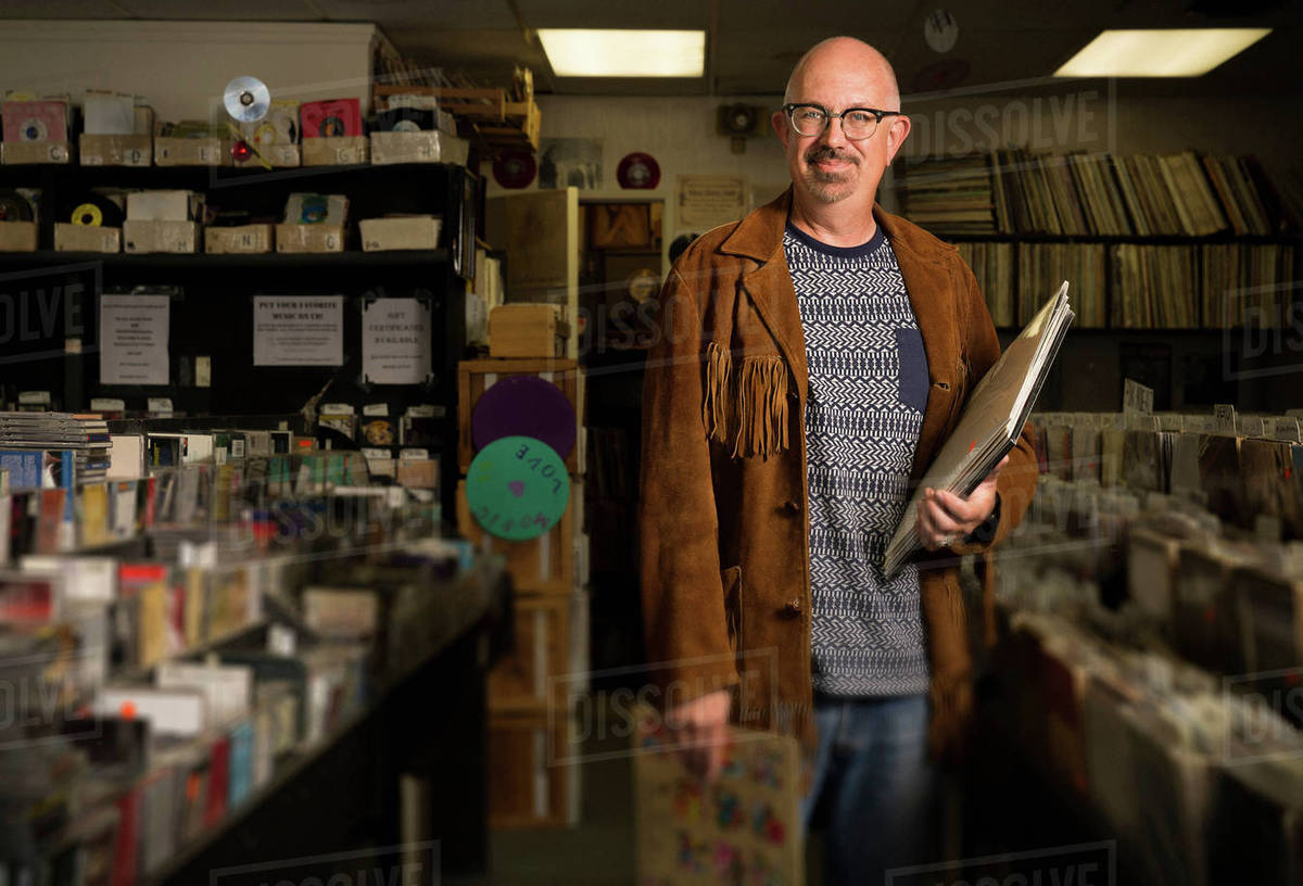 Portrait of mature man in record shop, holding records - Royalty-free ...