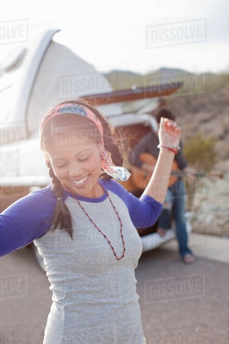 Young woman dancing on road - Stock Photo - Dissolve