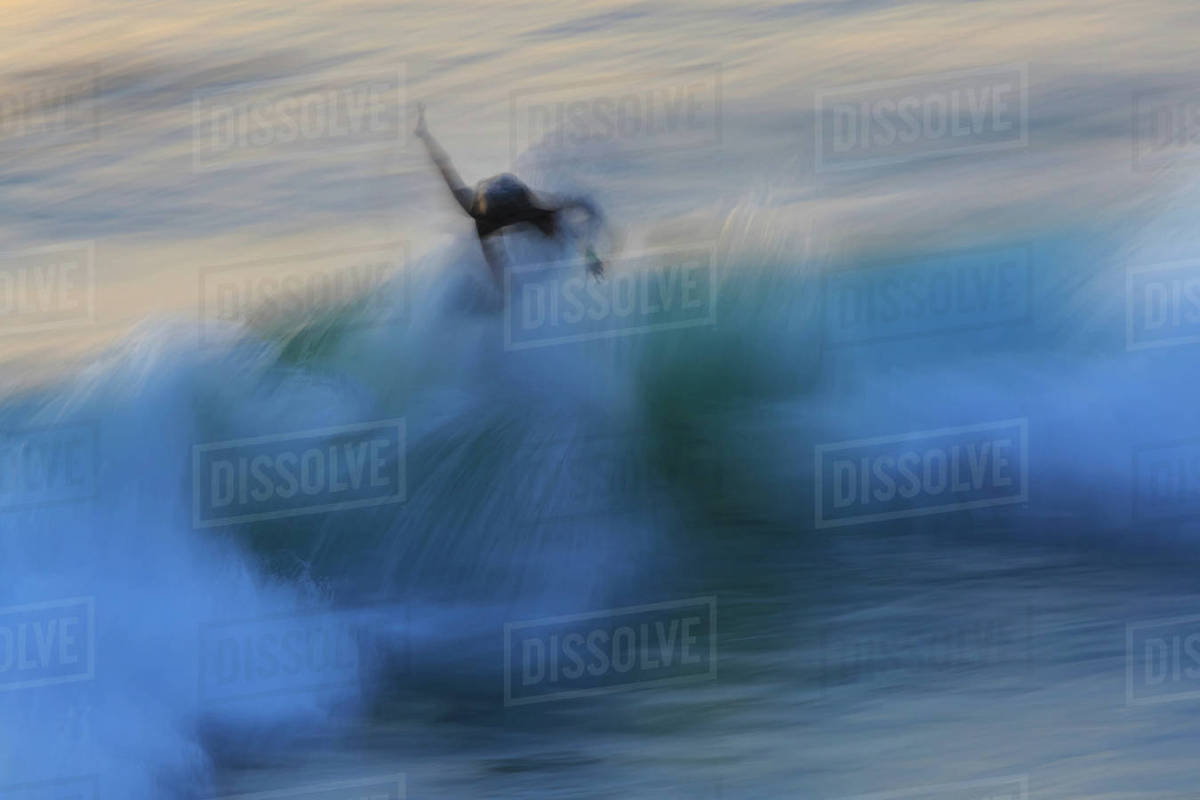 Motion blur of surfer surfing wave patterns after sunset, Pacific Beach ...