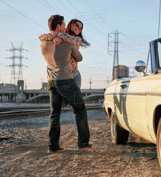 Couple hugging by convertible classic car, Los Angeles, California, USA ...