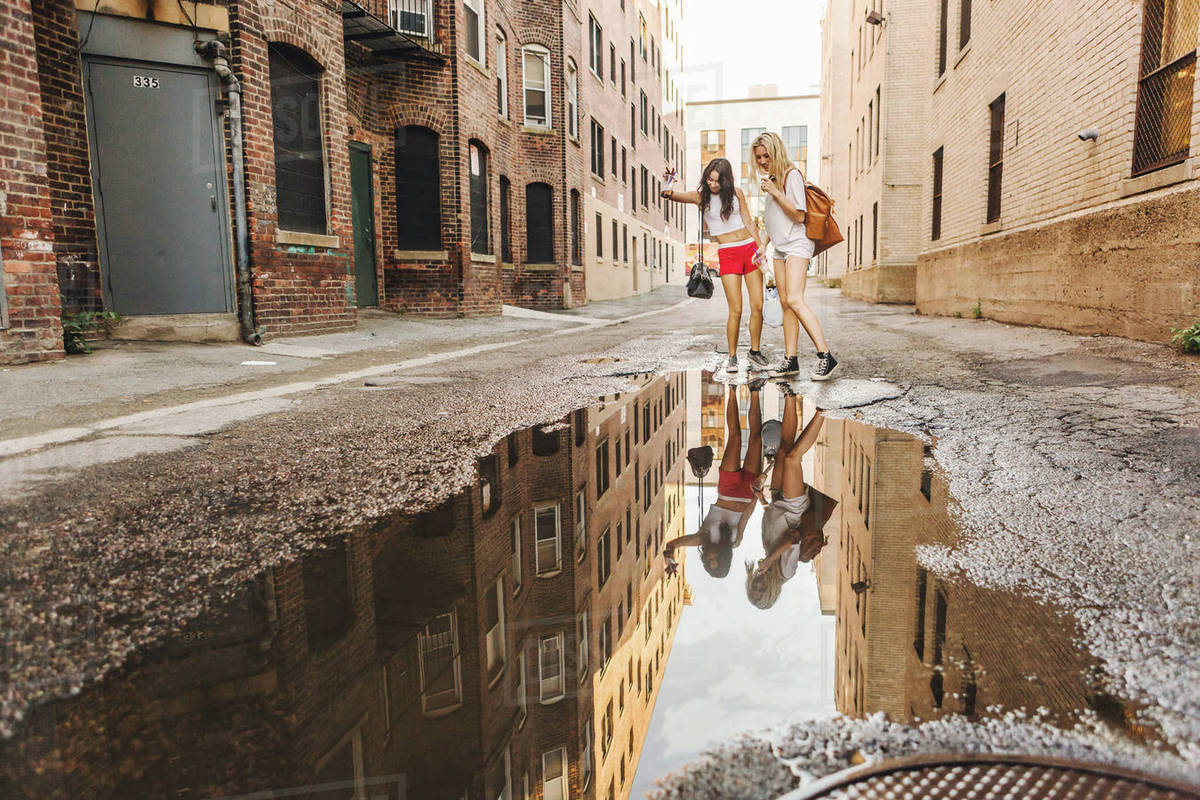 Women walking through puddle on road, Boston, MA, USA - Stock Photo ...