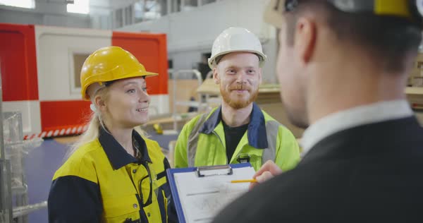 Male inspector making inspection report in big industrial manufacturing ...