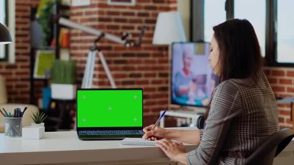 Teleworker staying at home using green screen laptop to do various job ...