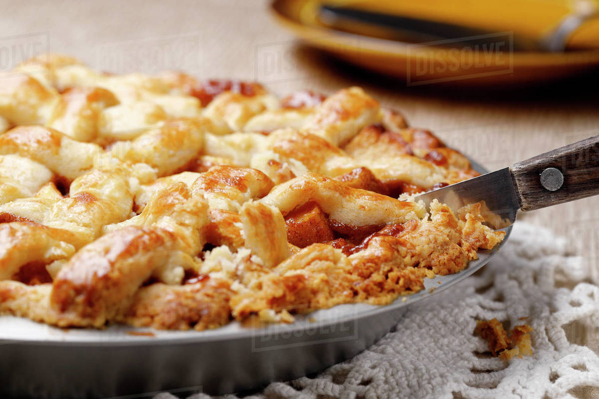 Cutting into a delicious home baked apple pie on the table. - Royalty ...