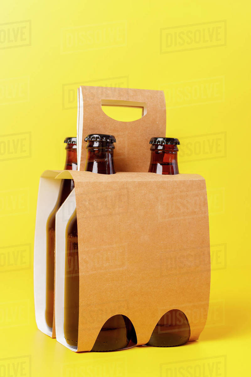 Presentation of pack of four beers with yellow background - Stock Photo ...