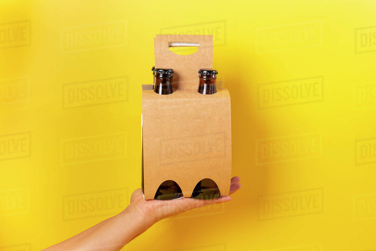Hand holding a four-pack beer - Royalty-free Stock Photo | Dissolve