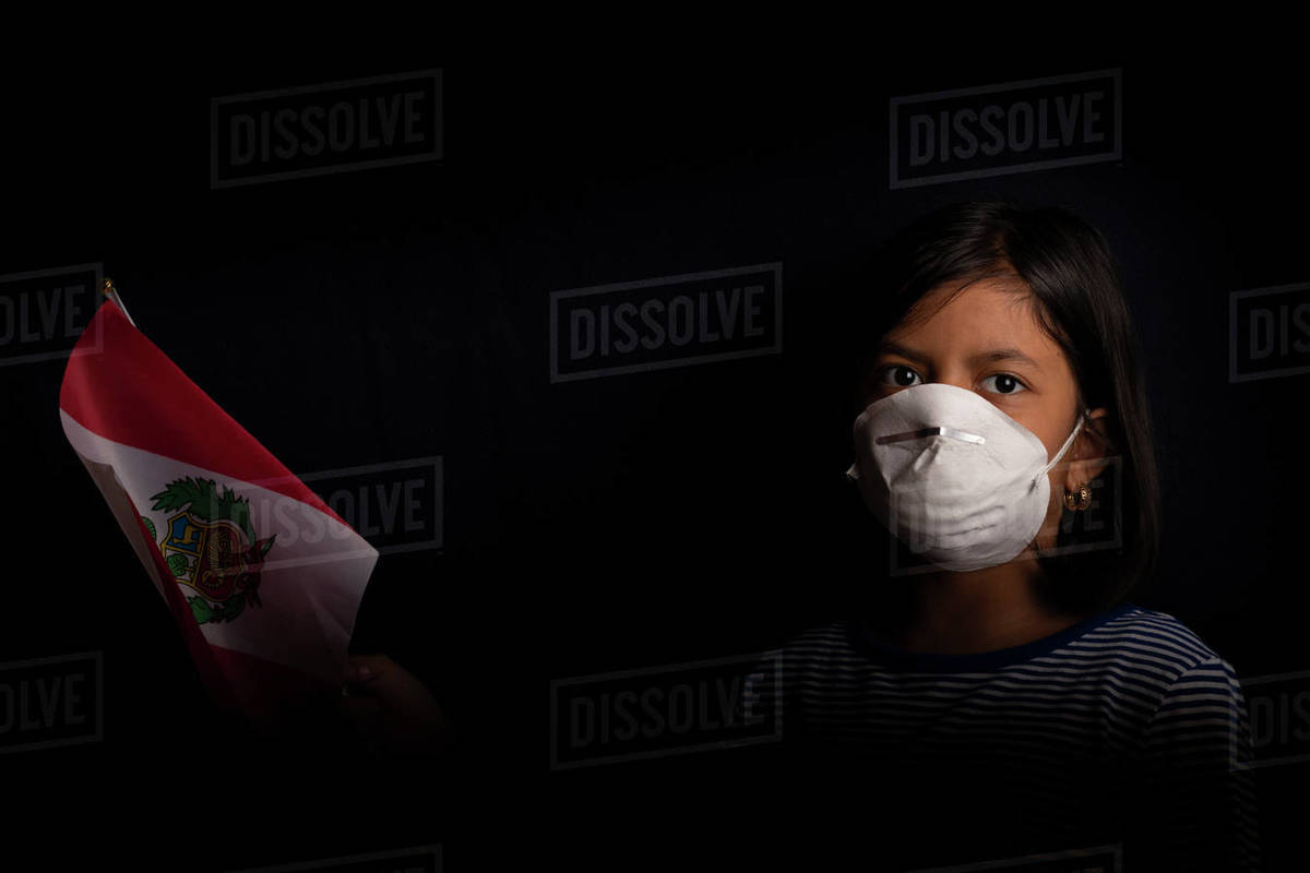 Portrait of little Peruvian girl wearing medical mask and holding ...