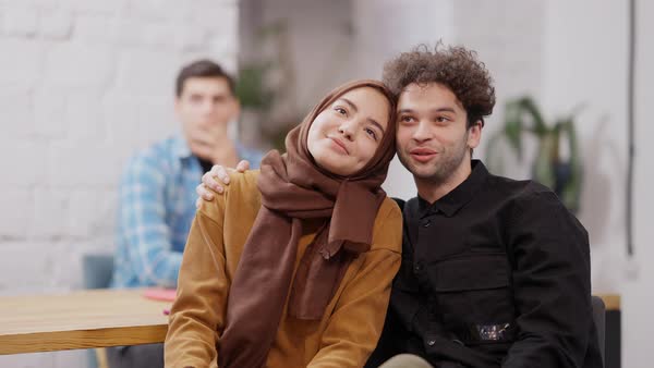 Happy loving Muslim couple sitting in cafe hugging and talking with ...